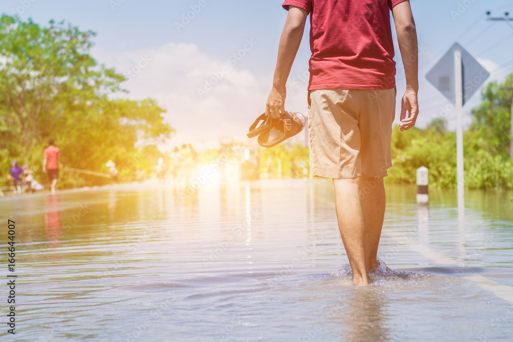 young man walks through the flood with his bare feet. Stock Photo ...
