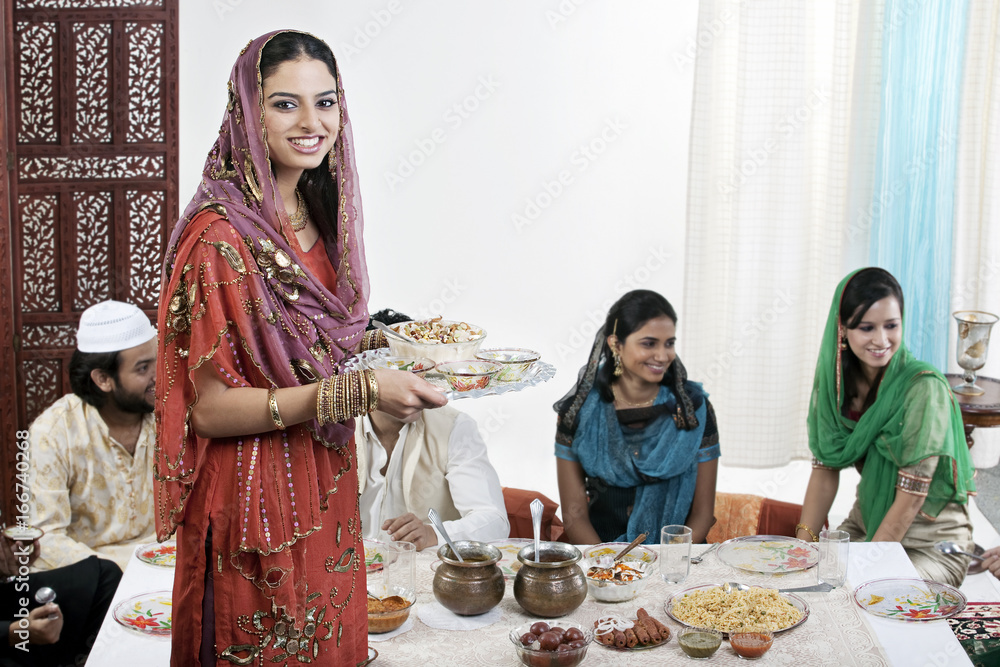 Muslim woman serving food during Id Stock Photo | Adobe Stock
