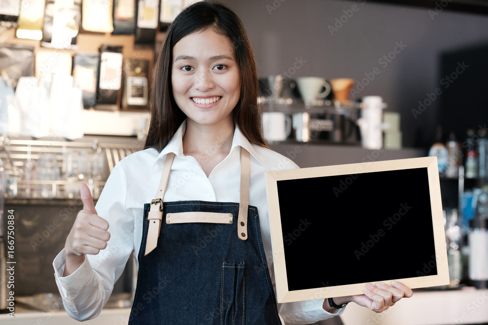 Young asian women Barista holding blank chalkboard and thumb up gesture ...