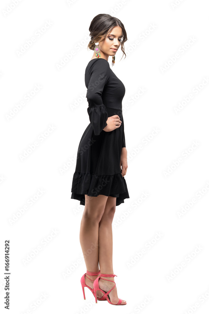 Side view of gorgeous woman in black dress with bun hair looking down ...