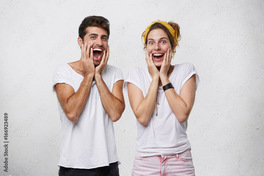 Omg! Indoor shot of happy excited young male and female screaming in ...