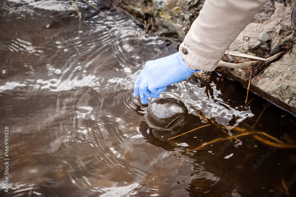 hand in glove collects water sample to explore and testing for ...
