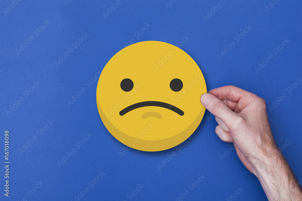 Male hand holding a emoji emoticon unhappy smiley head icon Stock Photo ...
