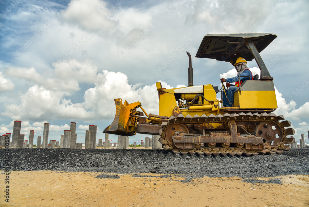 Construction worker in safety uniform driving grader tractor or ...