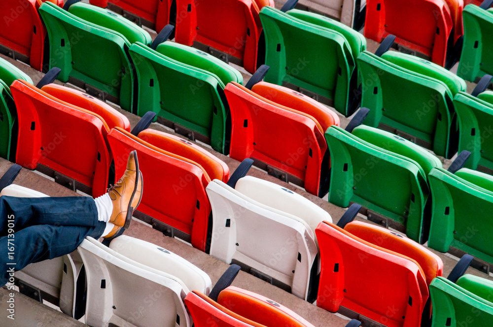 Folding plastic chairs in green, white, red, orange at an event. These ...