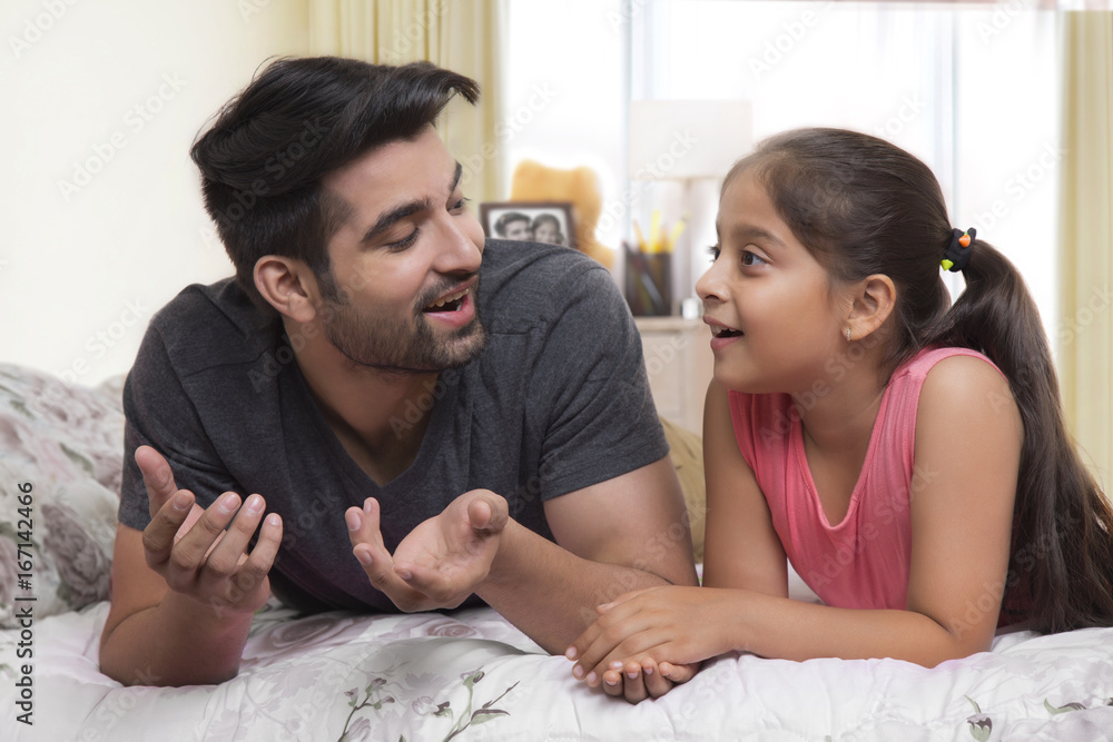 Father and daughter lying on bed and talking Stock Photo | Adobe Stock