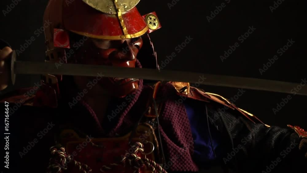 Vidéo Stock Samurai in a red armor and helmet demon mask becomes a ...