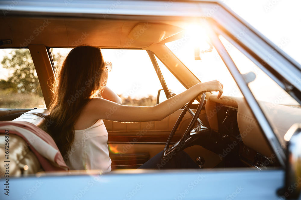 Side view of a young woman sitting inside a retro car Stock Photo ...