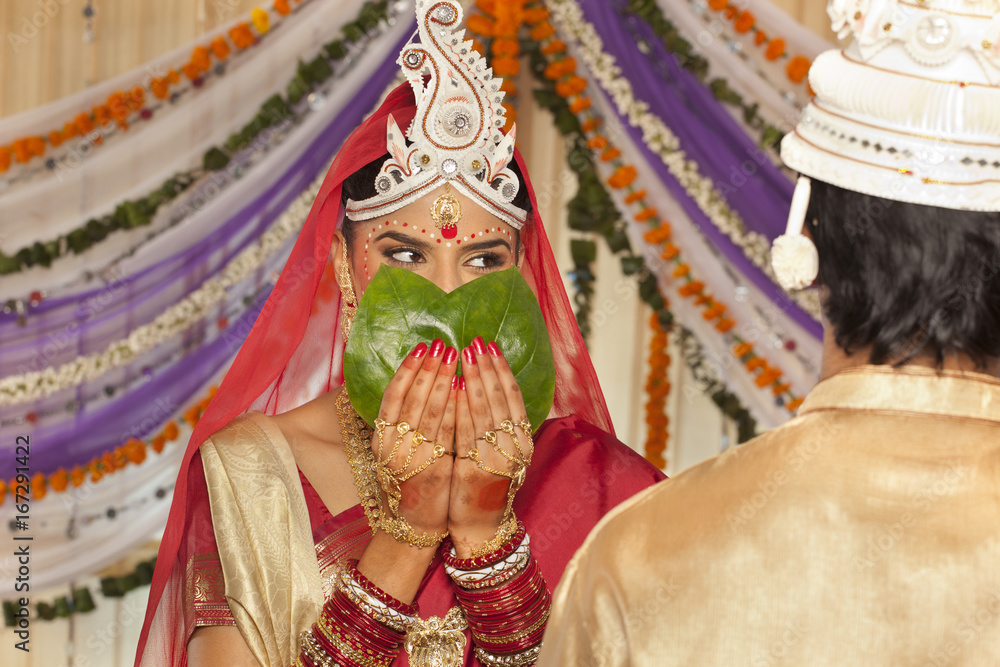 Bengali bride hiding her face from the groom Stock Photo | Adobe Stock