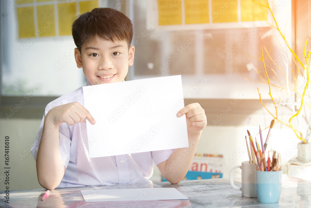 Happy asian boy hand holding blank A4 paper sheet and looking at camera ...
