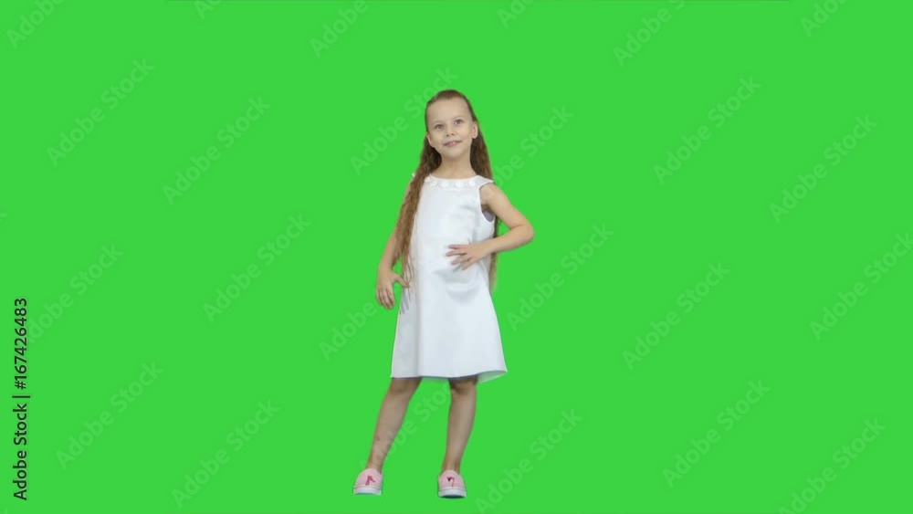 Adorable little girl smiling at camera and posing on a Green Screen ...