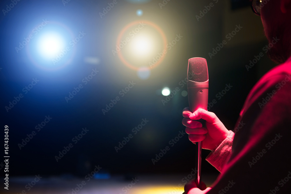 Singer holding a microphone and singing Stock Photo | Adobe Stock