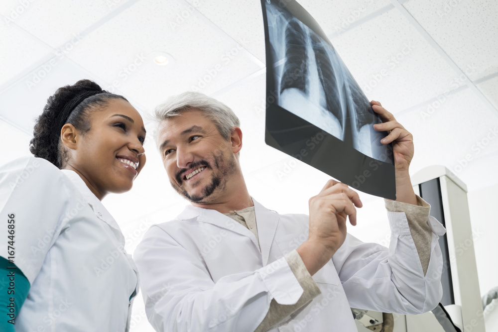 Smiling Radiologists Analyzing Chest X-ray In Examination Room Stock ...