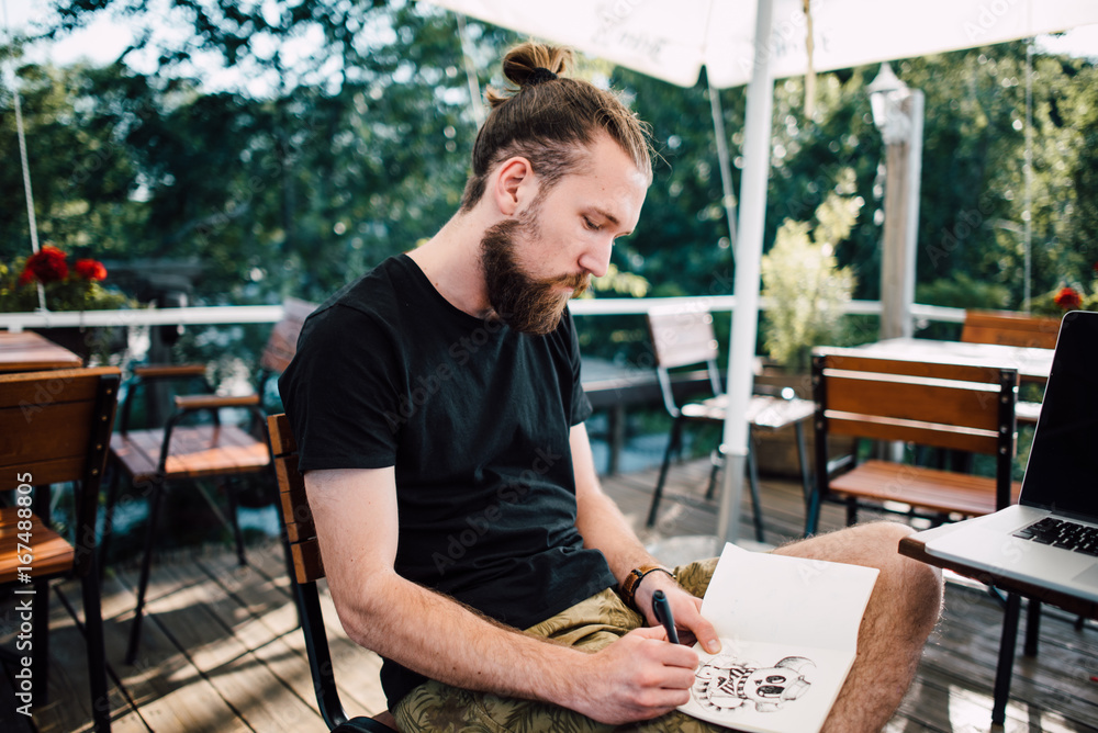 Man drawing an illustration in the sketchbook Stock Photo | Adobe Stock