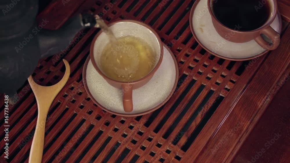 The action of traditional Chinese tea ceremony. Pouring tea from clay ...