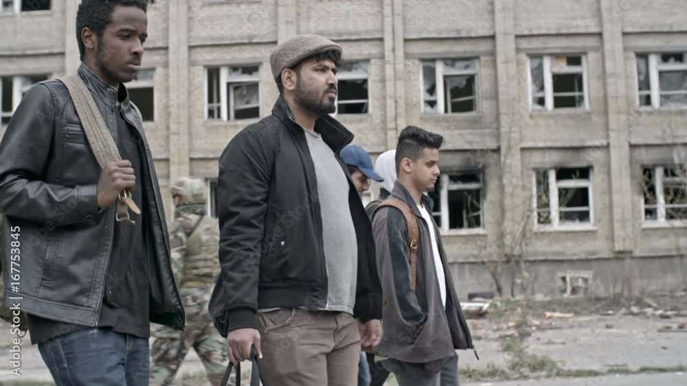 Video Stock Tracking with side view of male Arab refugees wearing ...