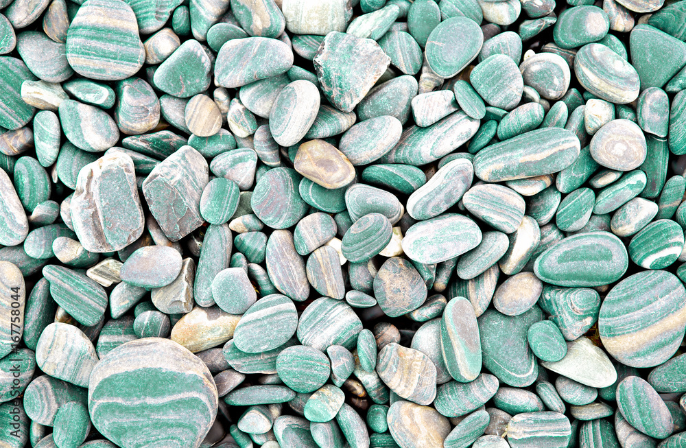 Abstract green dry round stones background. At the beach. Sea pebbles ...