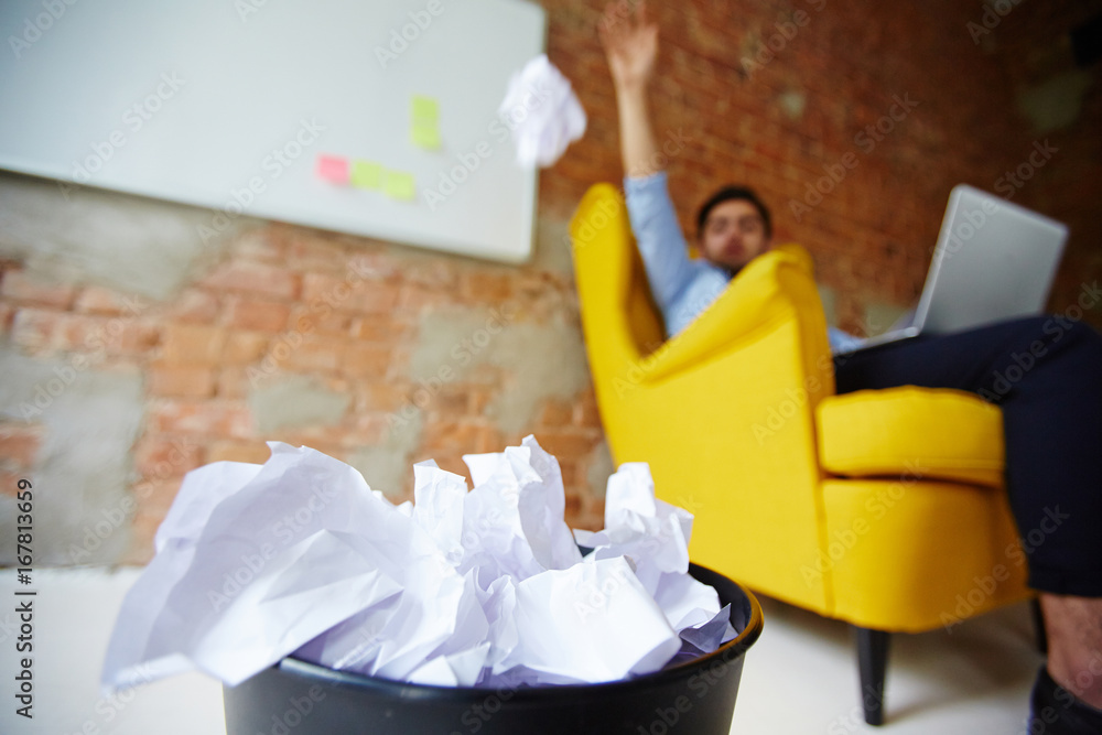 Modern freelancer throwing crumpled paper into trash bin Stock Photo ...