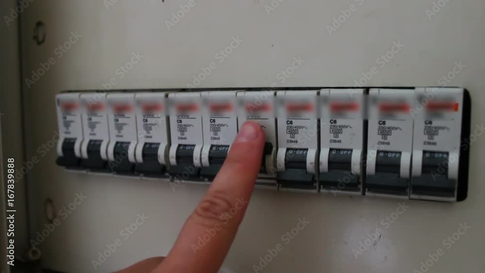 Female hand toggle switch in the switch box, All switches being turned ...