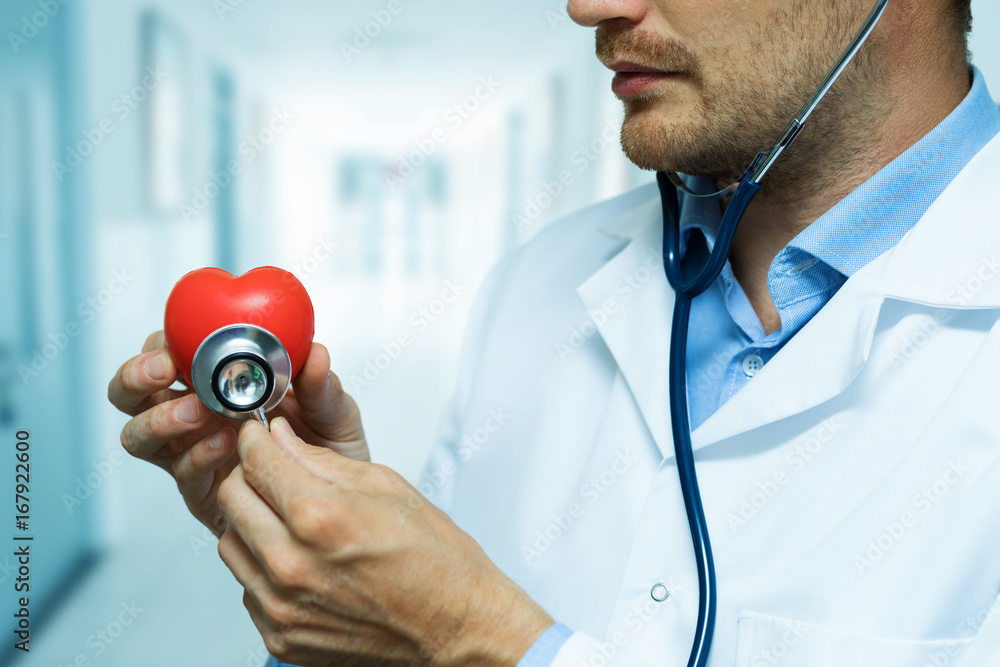 cardiologist checking red heart with stethoscope. cardiology concept ...