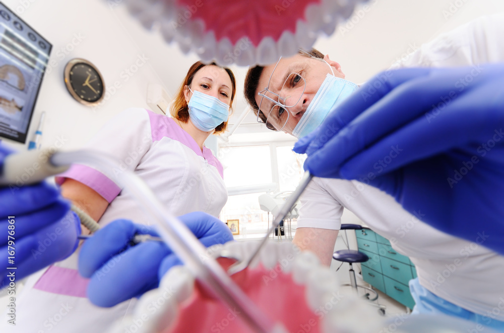 Dentist male and assistant girl visiting the oral cavity and the ...
