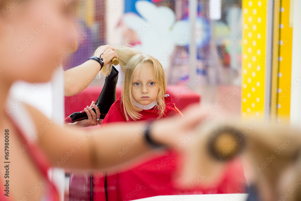 Little girl makes the haircut in the barber shop. Happiness. Stock ...
