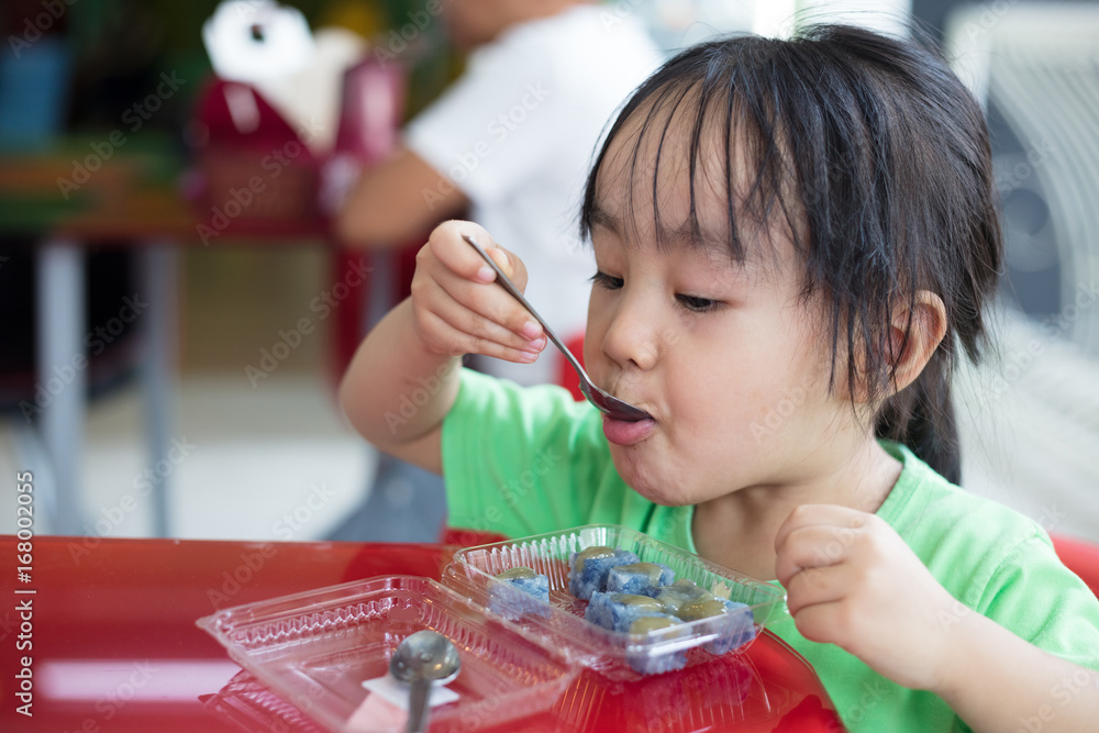 Asian little Chinese girl eating glutinous rice Stock Photo | Adobe Stock