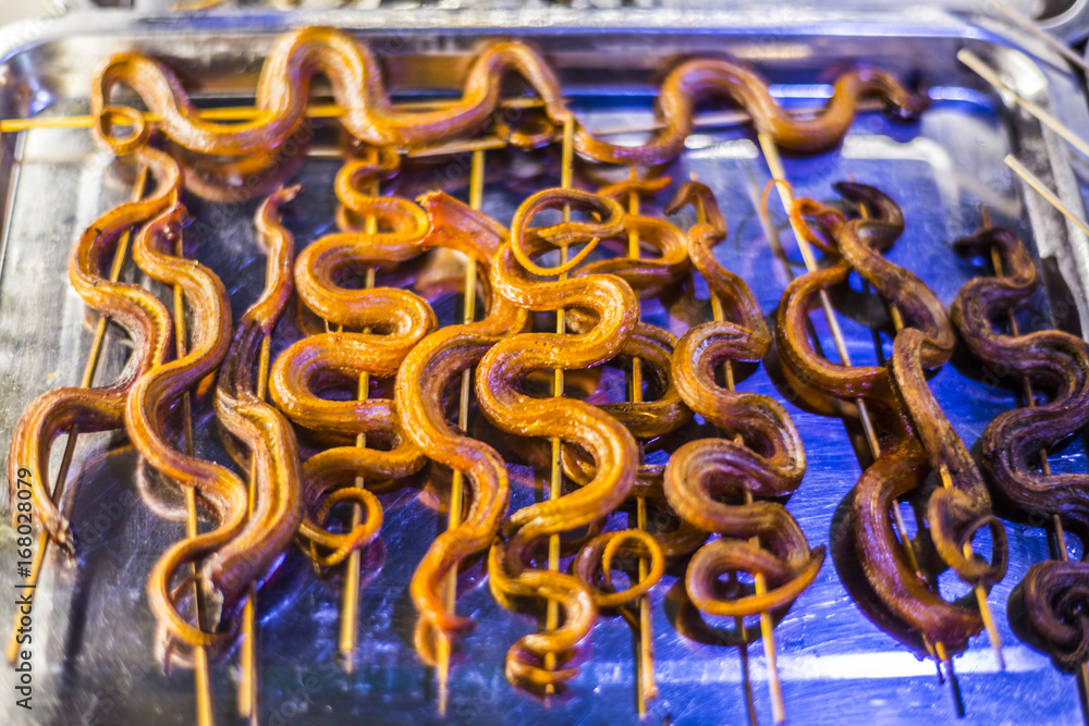 Cambodian street food with snakes on sticks Stock Photo | Adobe Stock