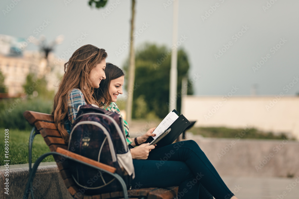 Trendy girl sitting on wooden bench. Keeping modish bag on bench ...