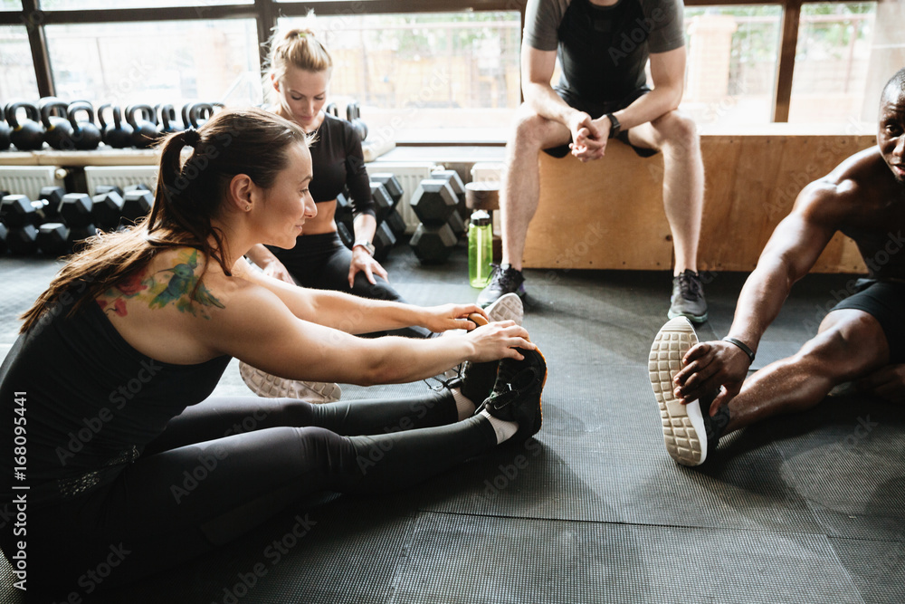 Sports strong people sitting in gym make stretching exercises Stock ...