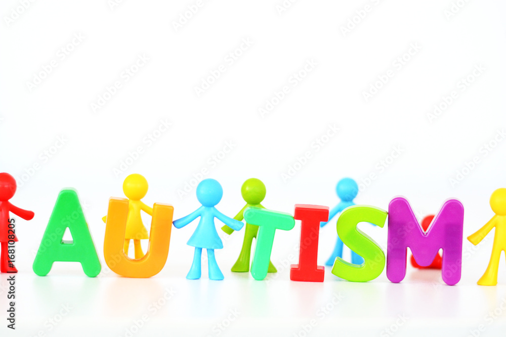 Colorful plastic letter spelling autism on white background with ...