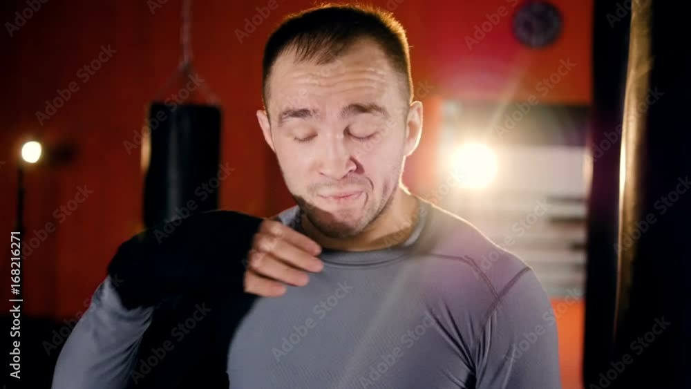 A tired MMA fighter stretches after training. Stock Video | Adobe Stock