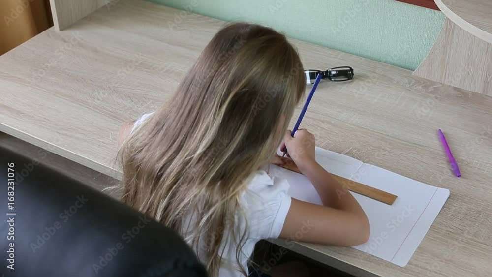 Little girl draw line by pencil with ruler in notebook. Back to school ...