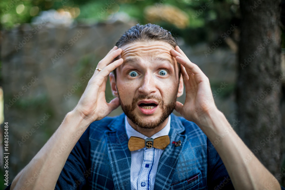 Man in a panic. The man is frightened and raised his hands to his face ...