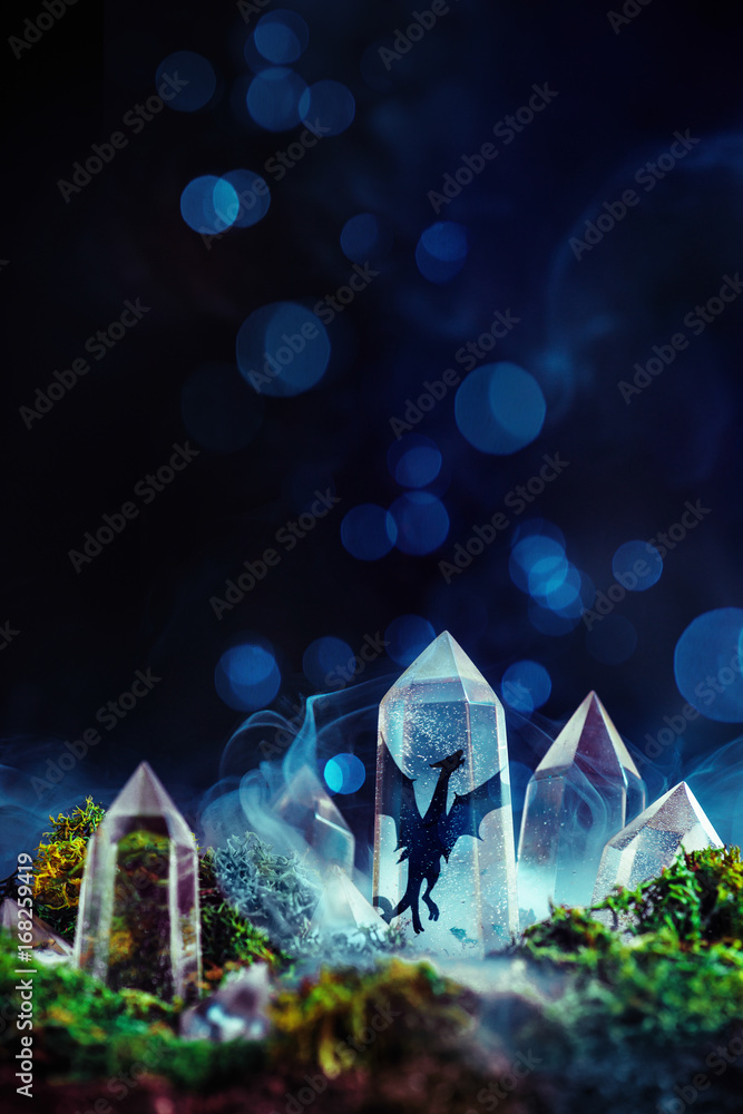 Magical scene with tiny dragon silhouette trapped inside a clear ...
