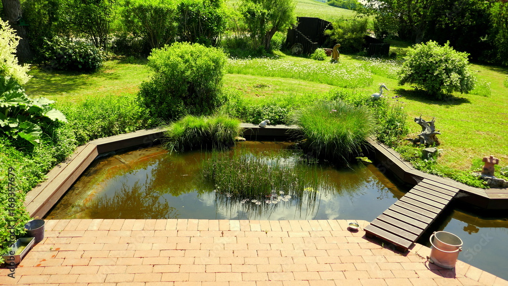 natürlicher Garten und schöner Teich an Terrasse angrenzend Stock Photo ...