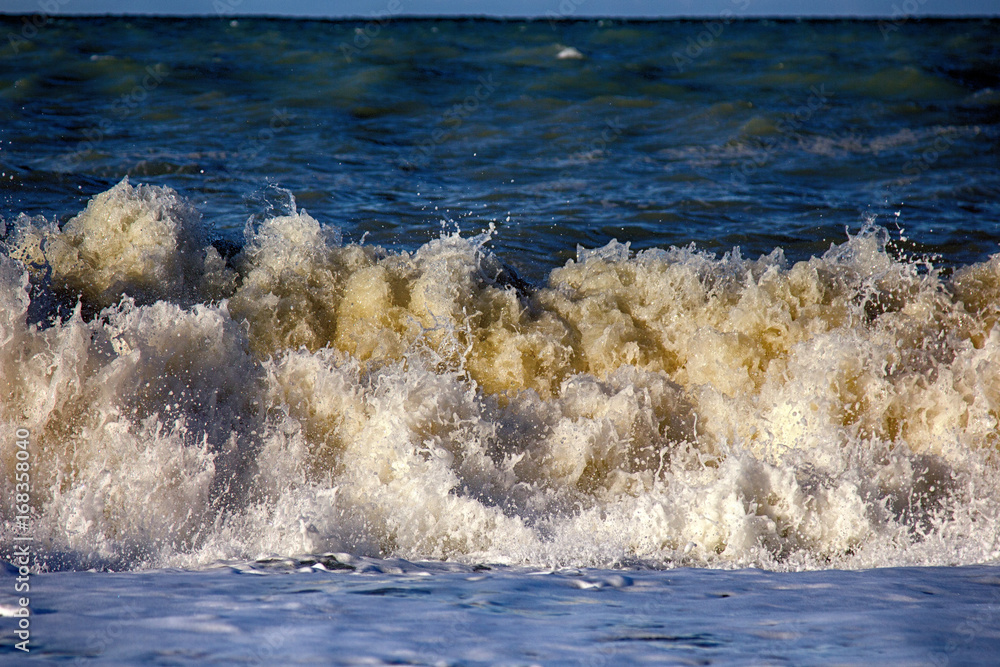 Sea rolling and receding water in rays of setting sun. Stock Photo ...