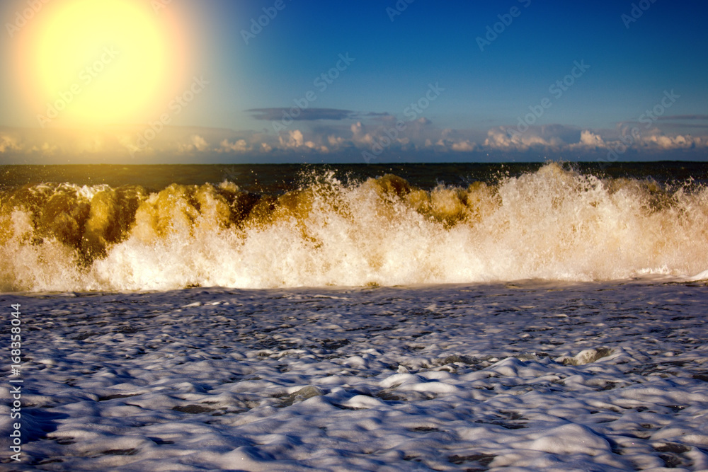 Sea rolling and receding water in rays of setting sun. Stock Photo ...