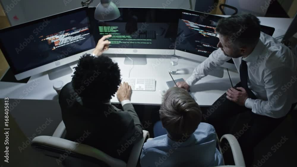 Top view of IT security team working with programming code on multiply ...