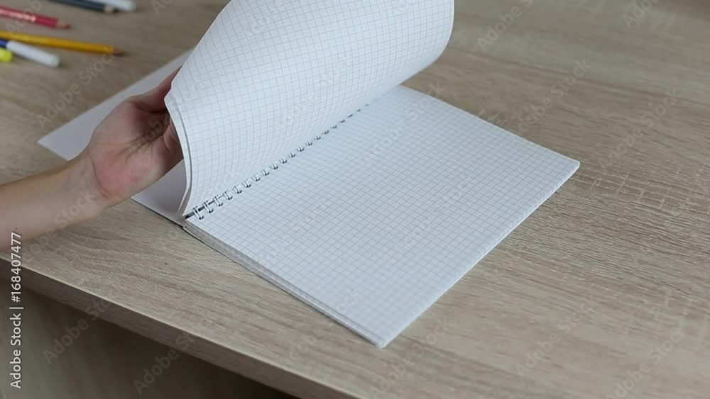 Girl's hand open notebook. Close up shot of ruled paper notebook with ...