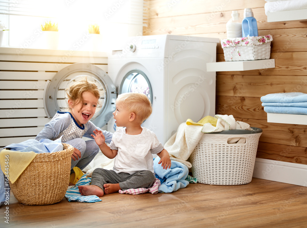 Happy children boy and girl in laundry load washing machine. Stock ...