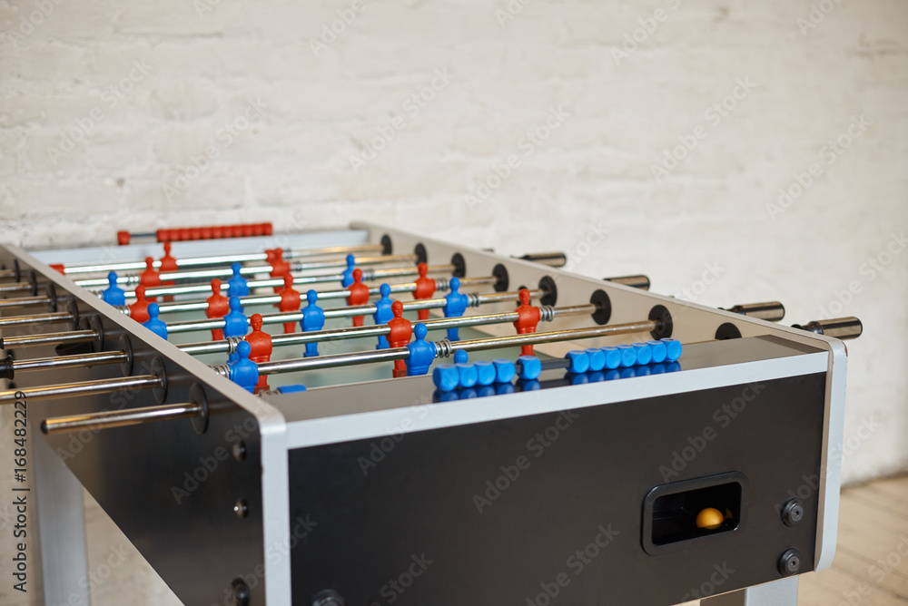 Detailed close up picture of foosball table with metall rods with red ...