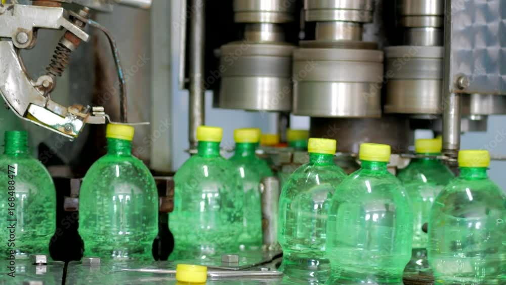 Automatic conveyor line for bottling mineral water in the green plastic ...