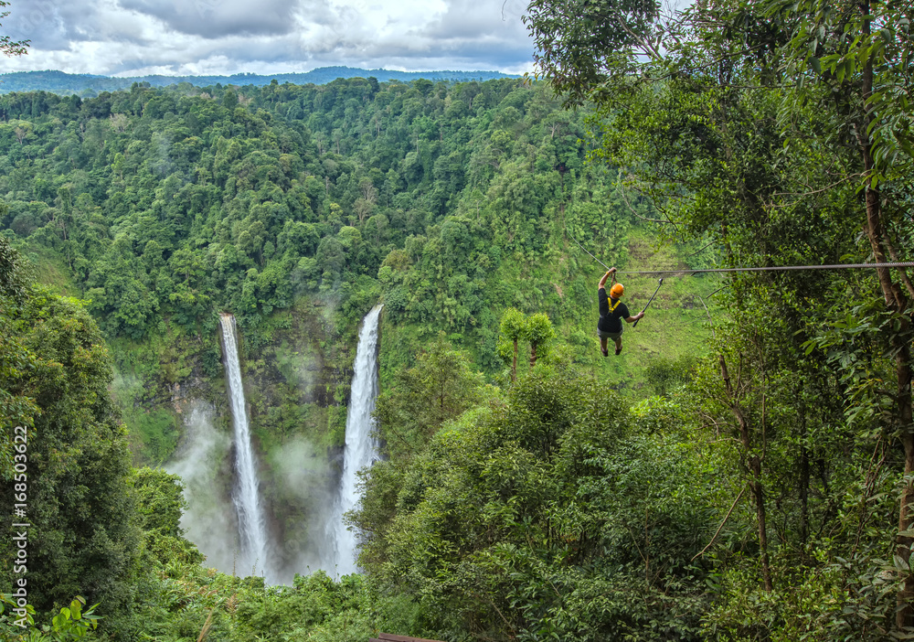 Tourists are playing zip line waterfall in Laos,Rainforest, Asia.It's ...