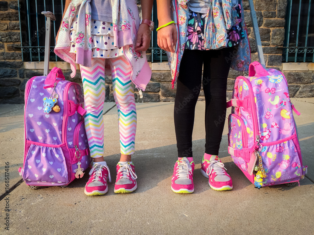 Girls first day of elementary school with rolling backpacks for saving ...