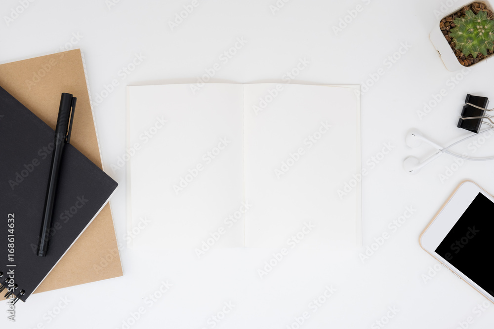 Blank notebook page on top of white office desk table. Top view, flat ...