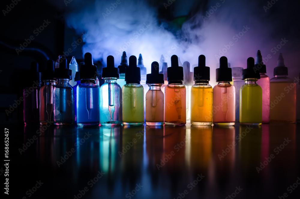Vape concept. Smoke clouds and vape liquid bottles on dark background ...