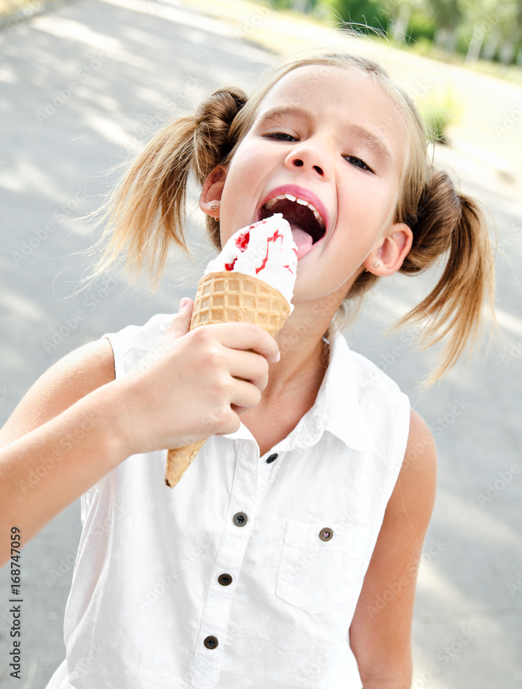 Cute smiling little girl eating an ice cream Stock Photo | Adobe Stock