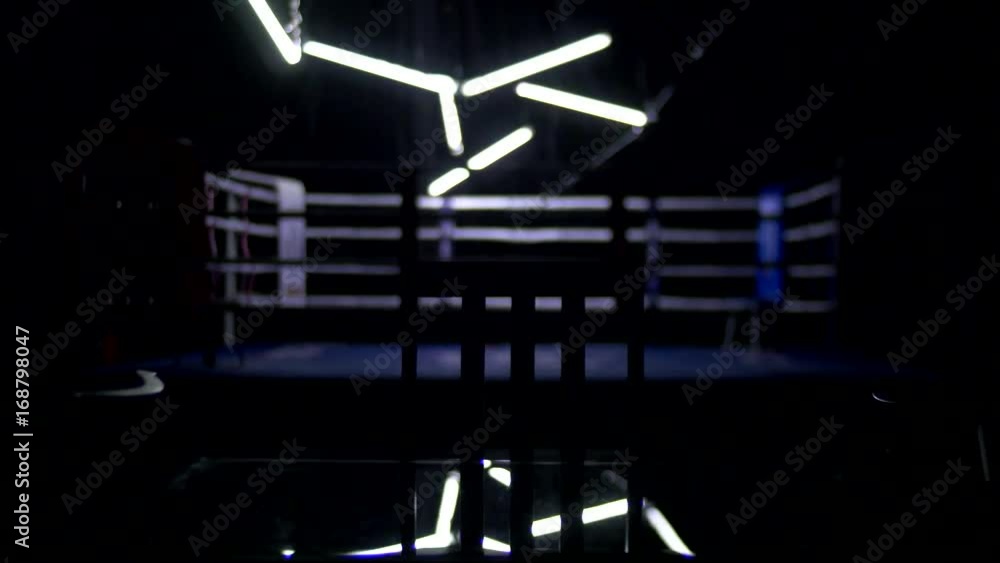 Boxing ring and two chairs with table dark background. View of a ...