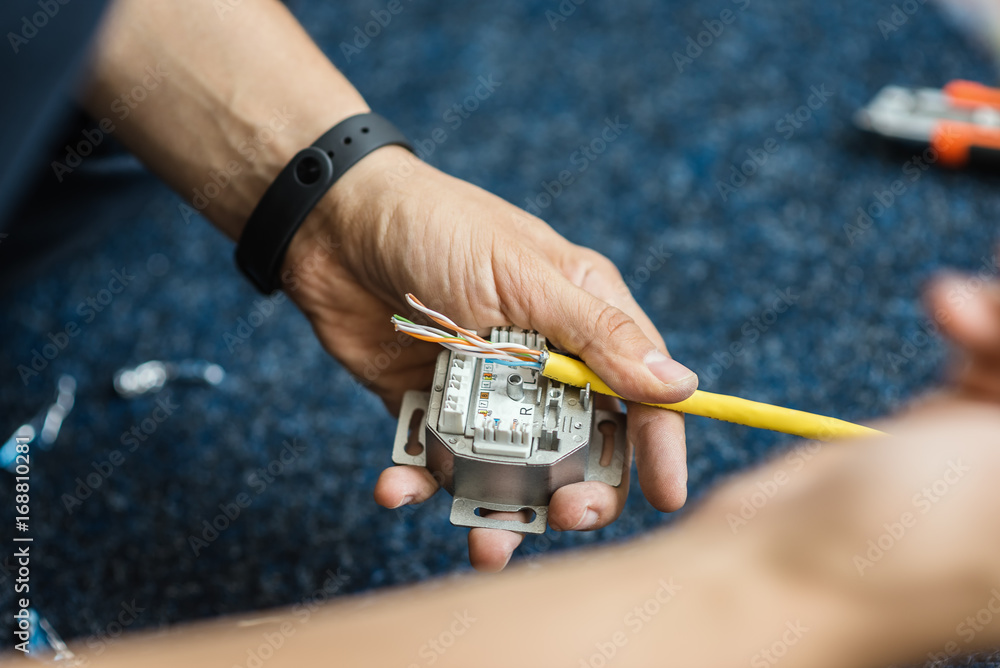 Specialist connect a network cable with RJ45 sockets, process of laying ...